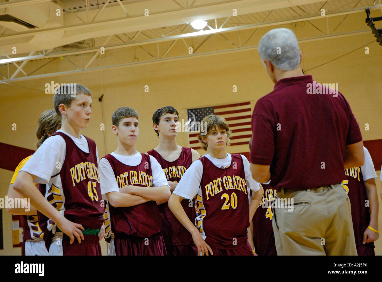 Coach of middle school grade 8 basketball team talks with member of ...