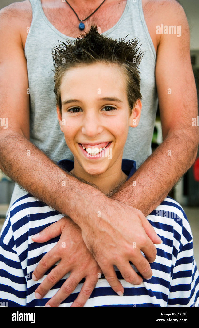 father hugs 11 year old son who smiles proudly into camera Stock Photo ...