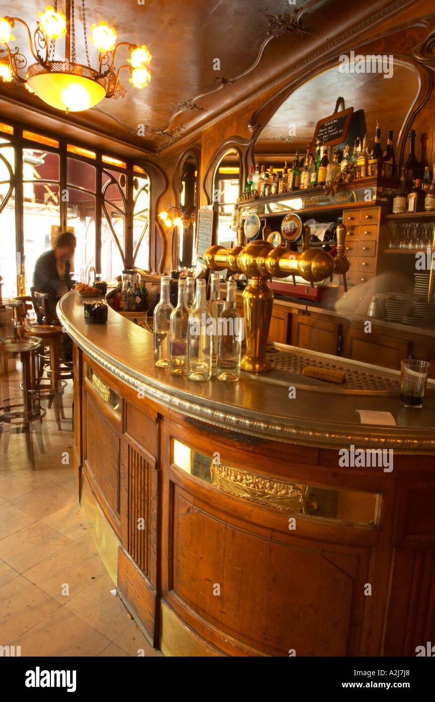 The curved bar zinc brass beer and water taps and water carafes blurred ...