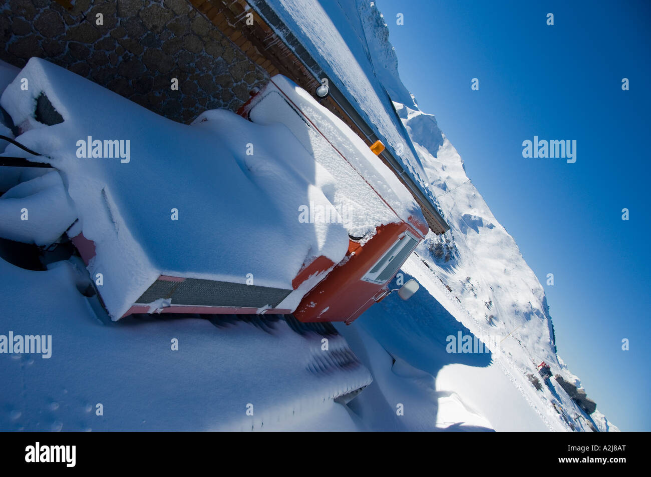 angled view of snow covered piste basher in the mountains Stock Photo ...