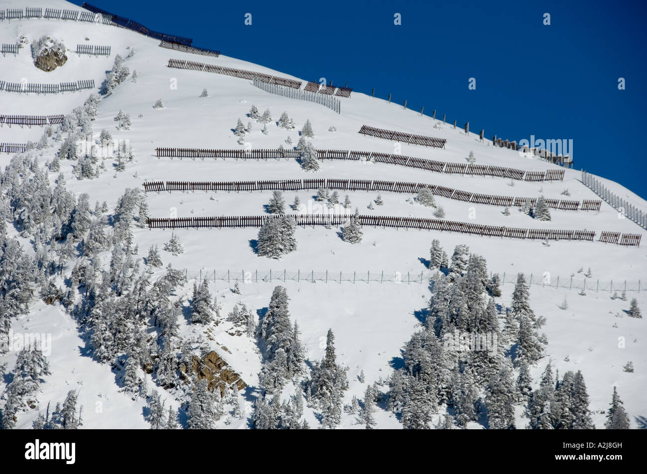 Avalanche protection barriers on a high mountain slope in the alps ...