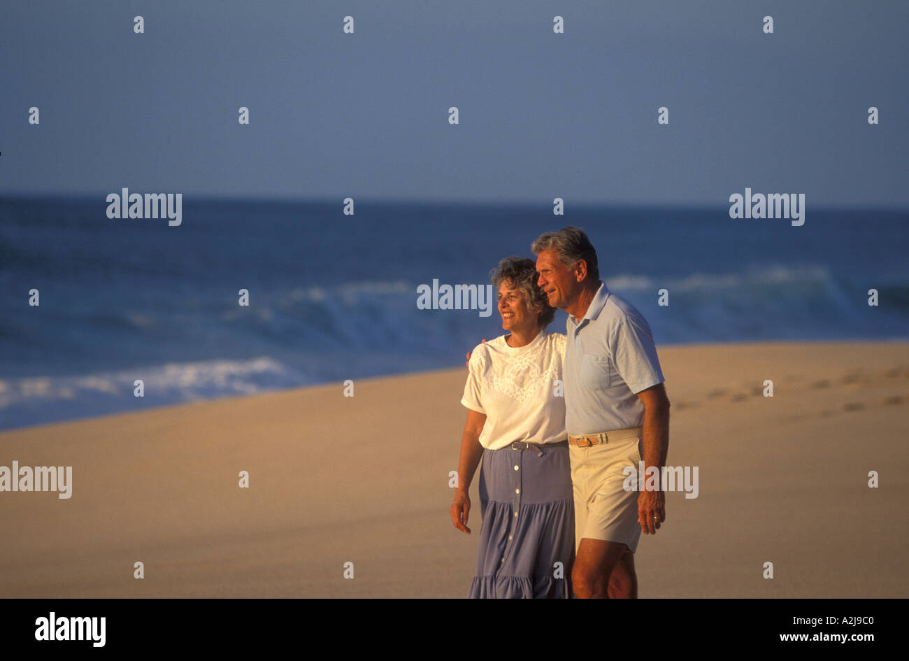 Casually Dressed Mature Couple Look Towards The Sun As They Walk