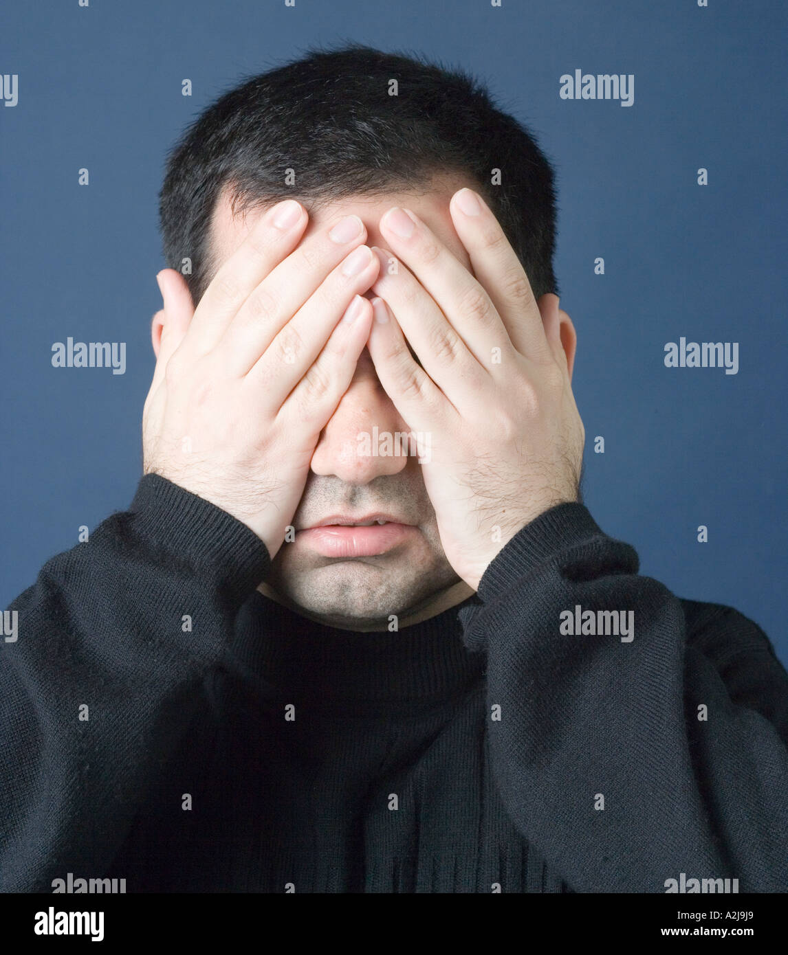 Man covering his eyes with his hands Stock Photo - Alamy