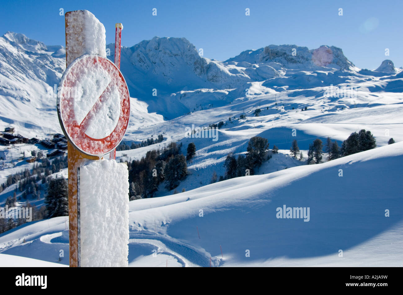 snow covered sign board on a white snowfield with mountains and an ...
