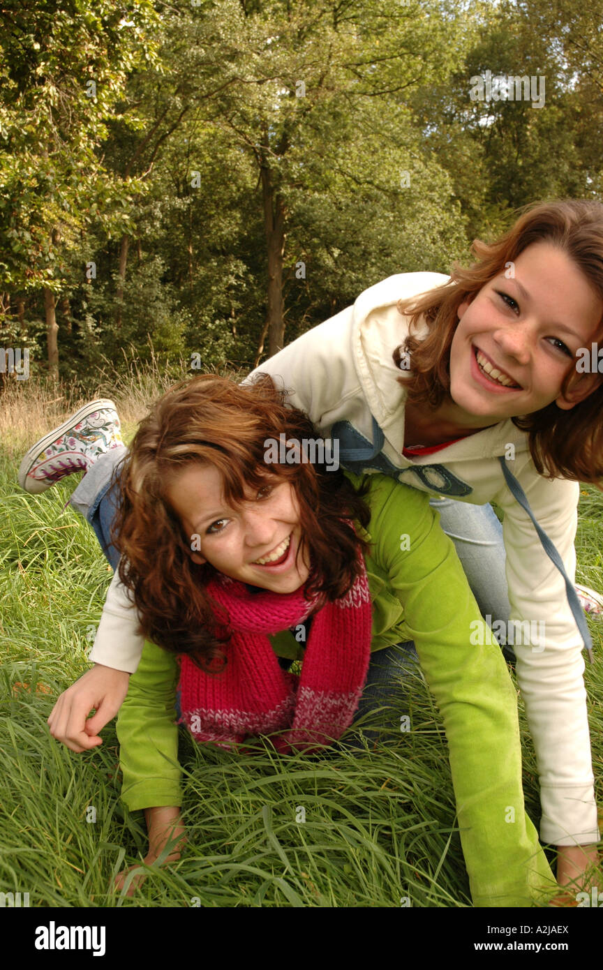 Two teenage sisters romping happily in the grass Stock Photo - Alamy
