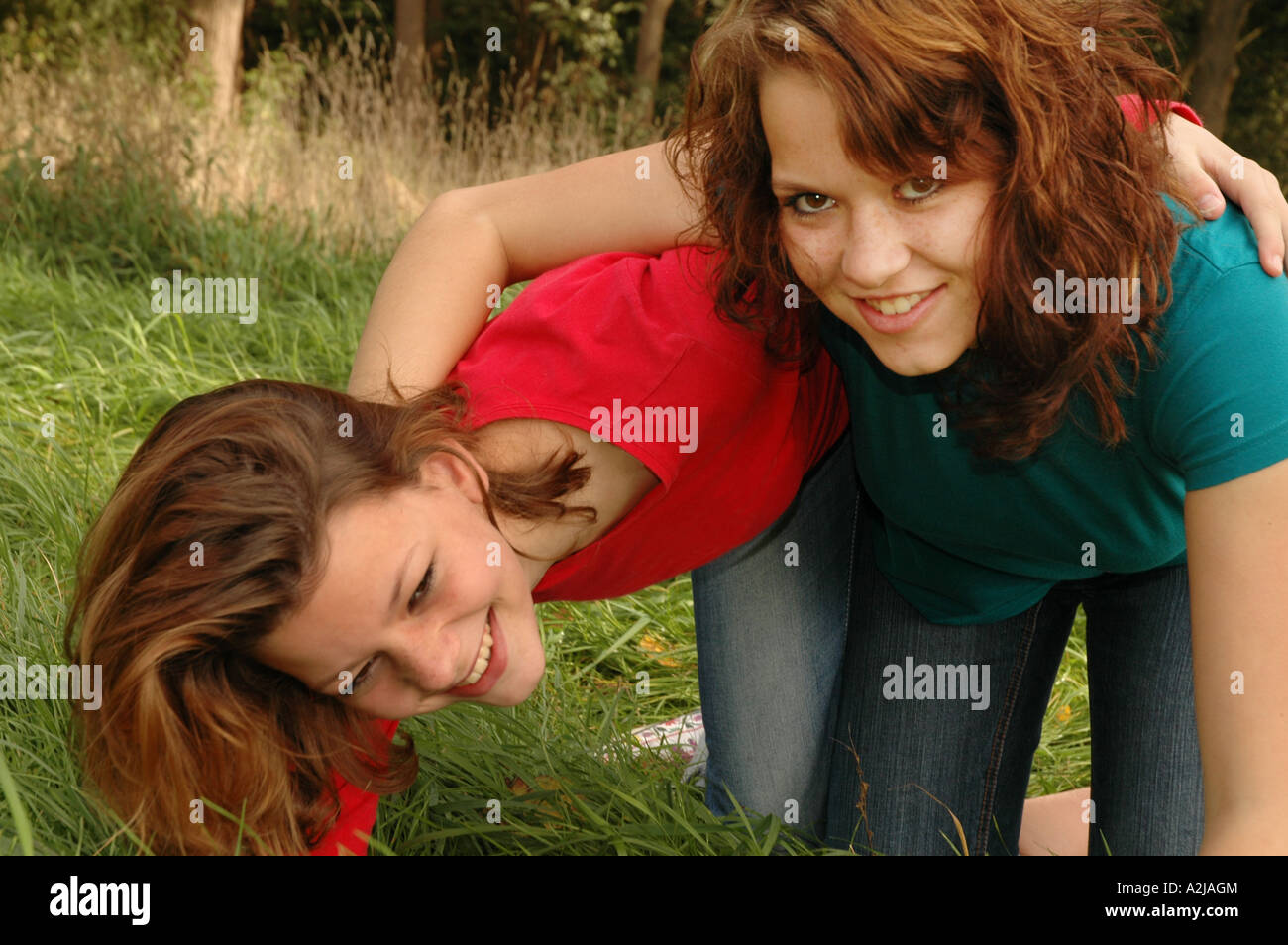 Two teenage sisters cheerfully frolicking in the grass Stock Photo - Alamy