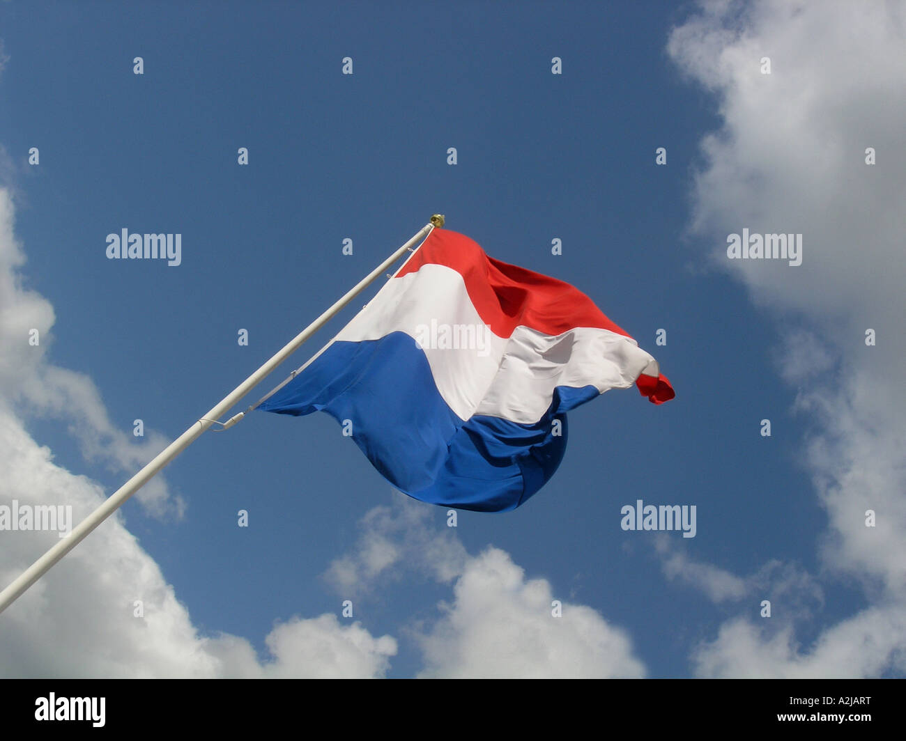 Dutch flag flying against blue skies with fluffy white clouds Stock ...