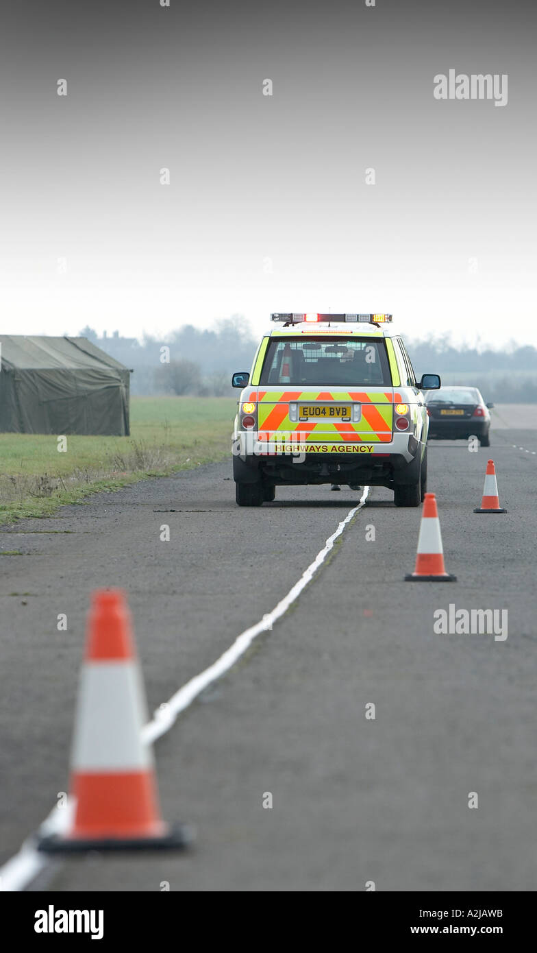 A highway police car cones off an area around a broken down car Stock ...