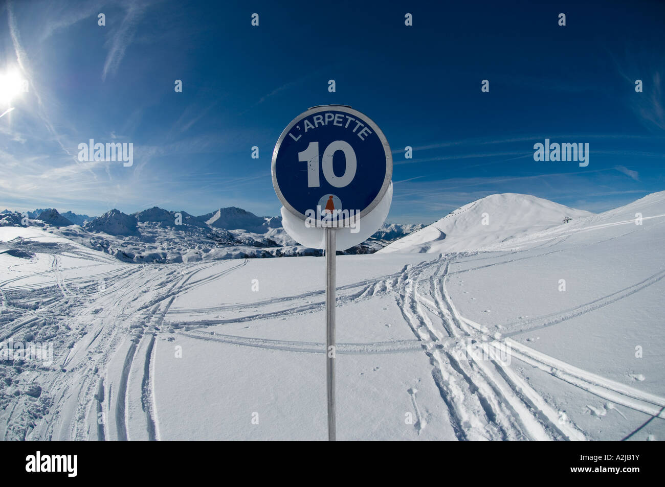 Ski piste sign with ski tracks on either side Stock Photo - Alamy