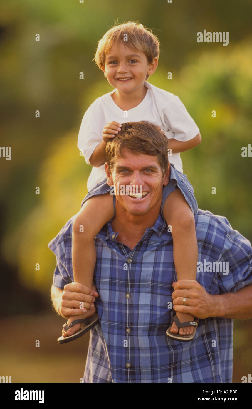 Portrait of a smiling father carrying his happy son on his shoulders outdoors Stock Photo - Alamy