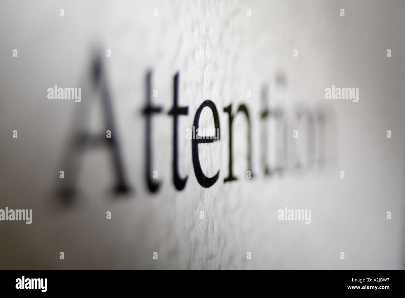 the word attention printed on to texture paper Stock Photo - Alamy