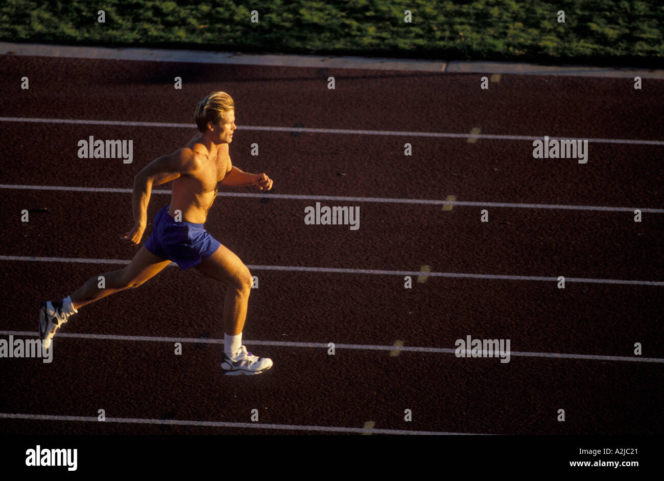 Shirtless man running on an outdoor track Stock Photo - Alamy