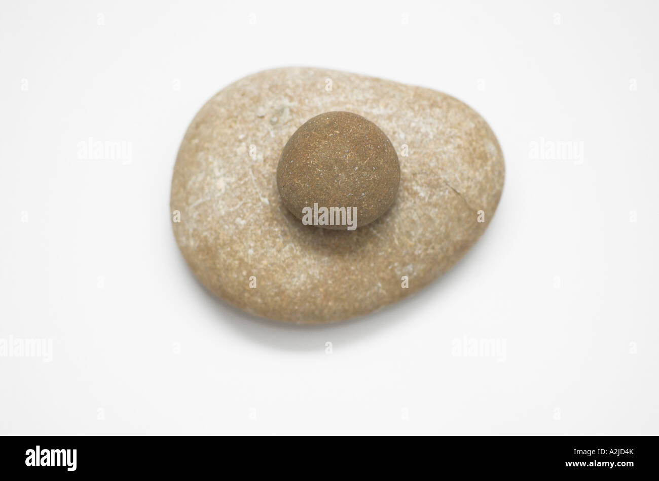 One small pebble on top of another elevated view Stock Photo - Alamy