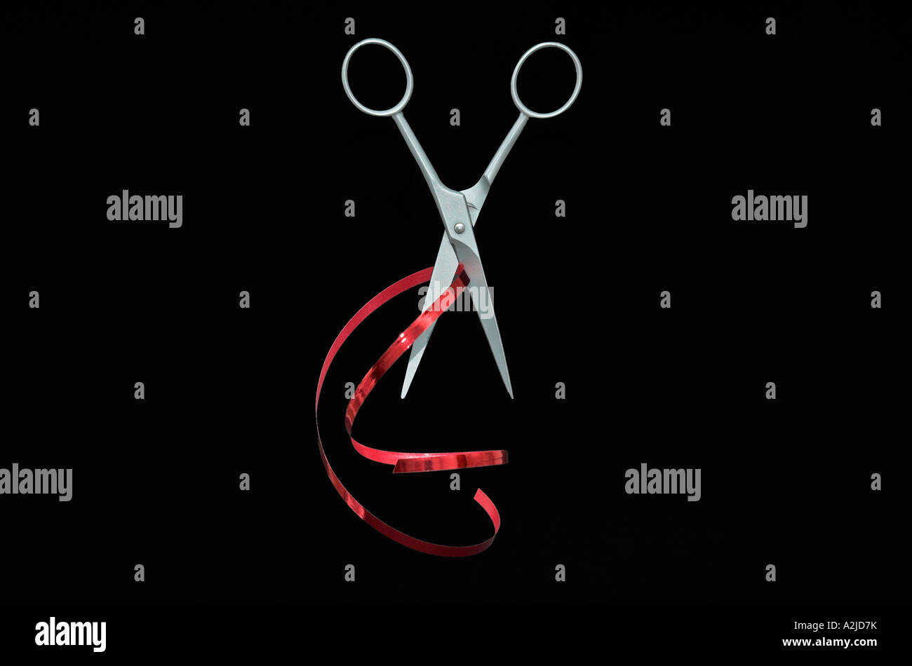 Scissors cutting red tape black background Stock Photo - Alamy