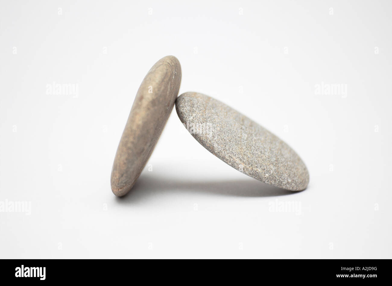 Large and small rounded pebbles leaning against one another side view ...