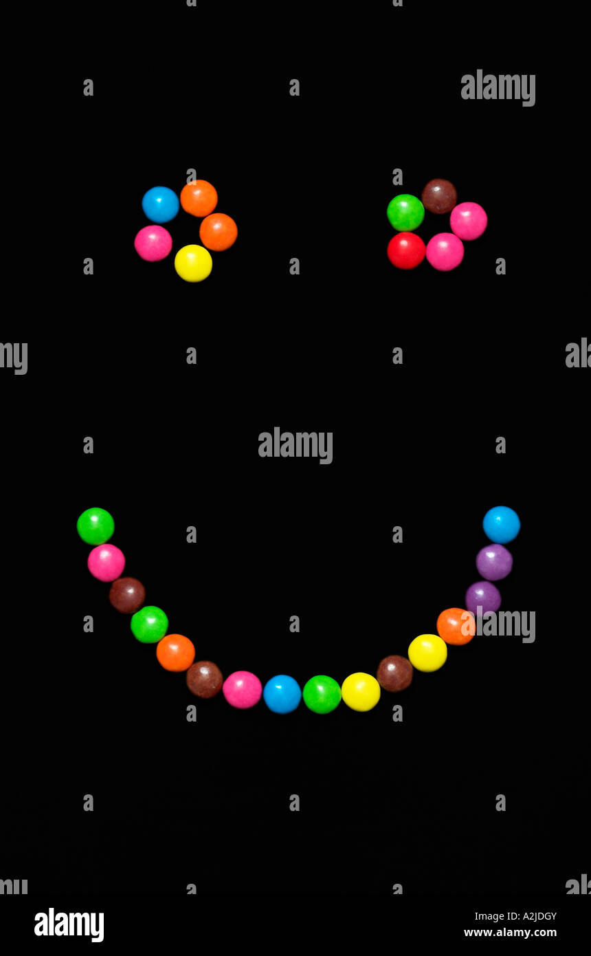 Colourful sweets forming smiley face on black background Stock Photo ...