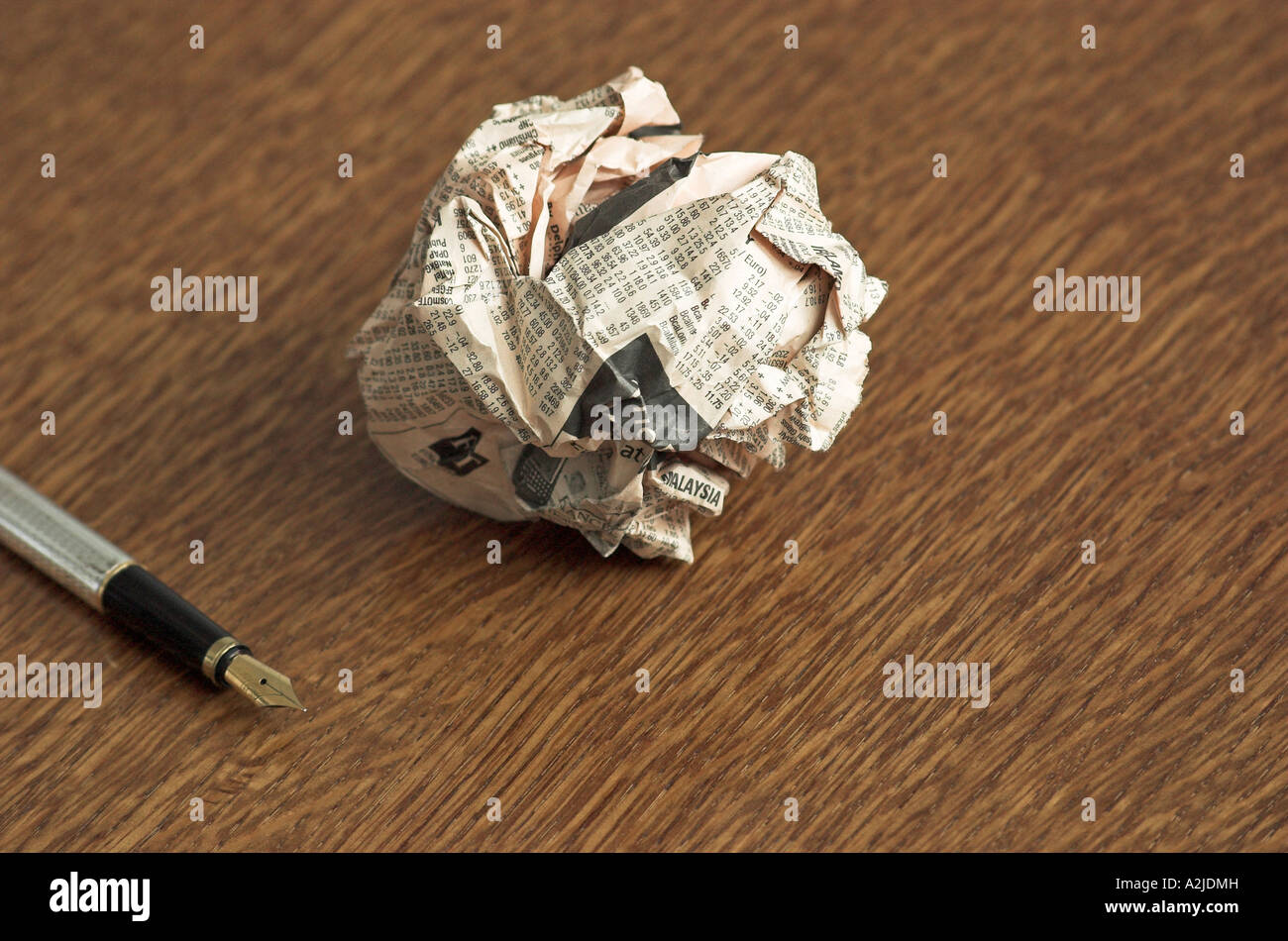 Scrunched ball of newspaper and fountain pen on table Stock Photo - Alamy