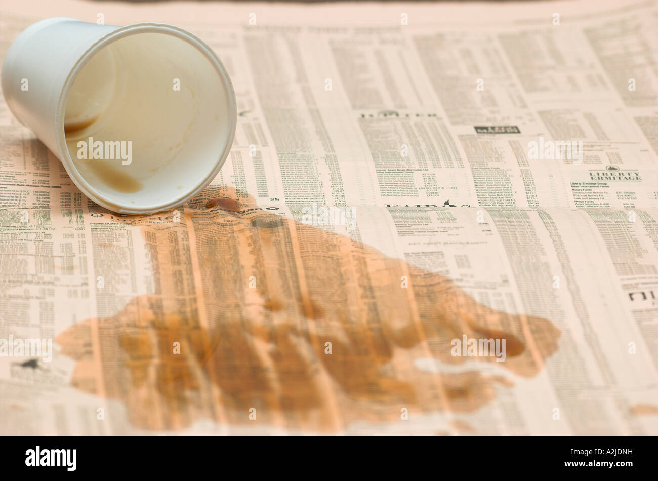 Spilt coffee over financial newspaper Stock Photo - Alamy