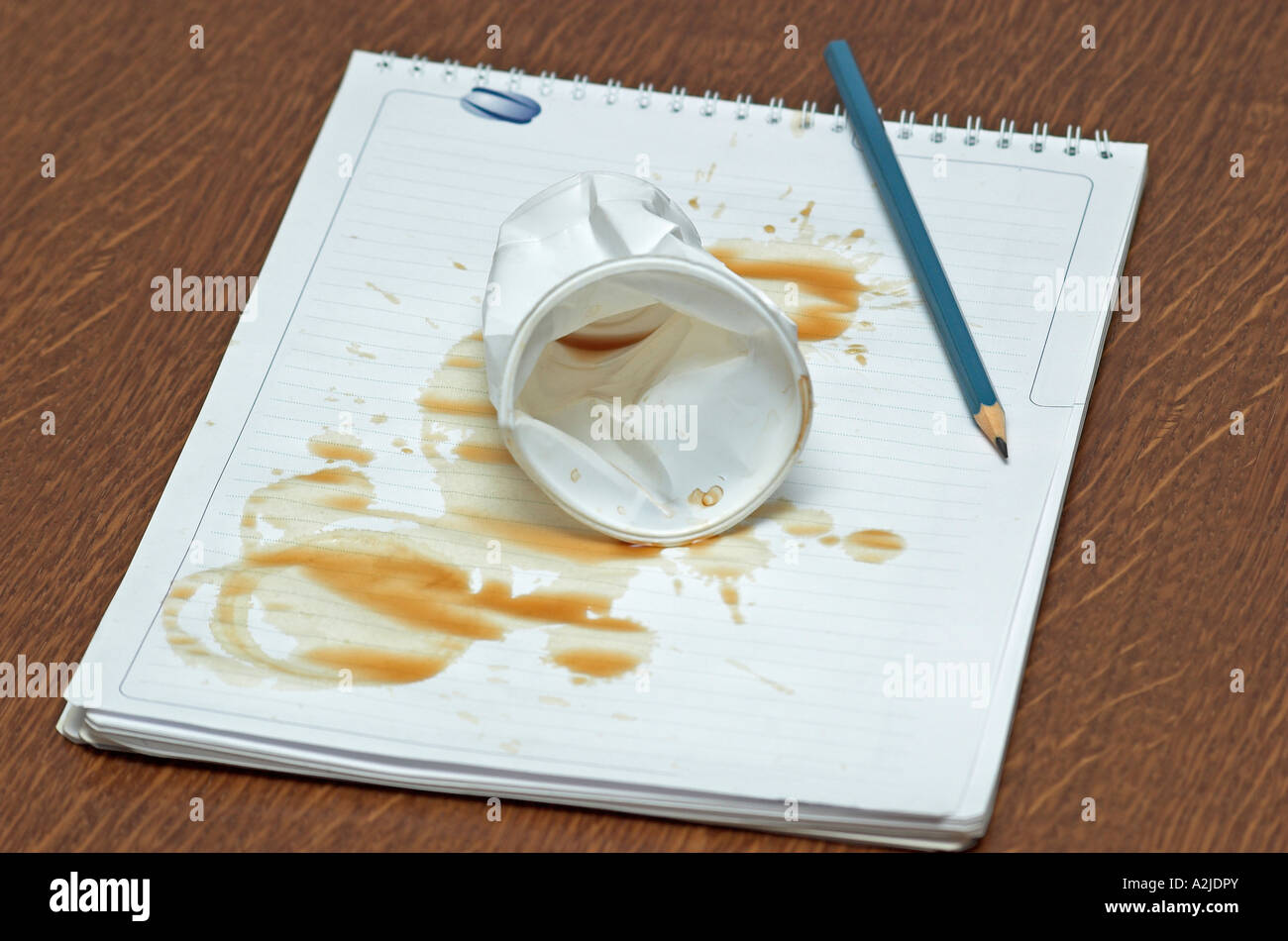 Pencil crushed coffee cup and spilt coffee over note book Stock Photo ...