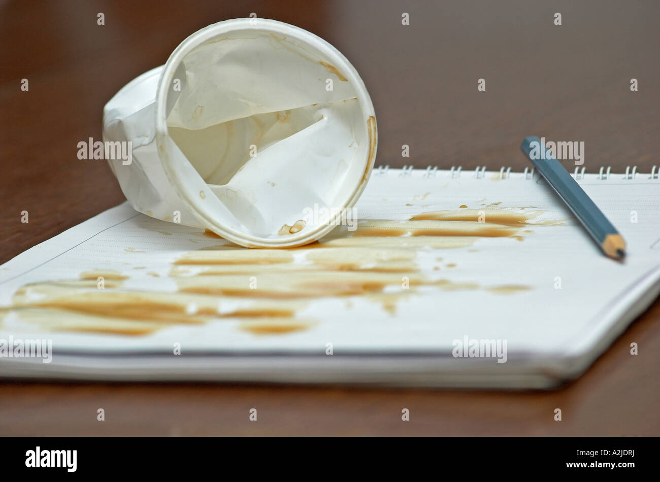 Pencil crushed coffee cup and spilt coffee over note book Stock Photo ...