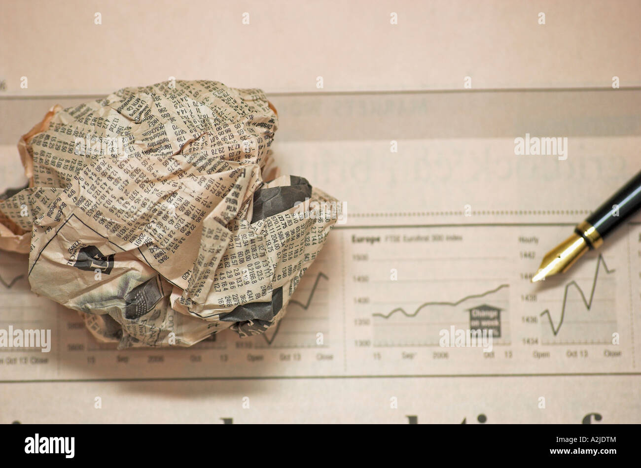 Fountain pen and scrunched ball of newspaper on flat page of newspaper ...