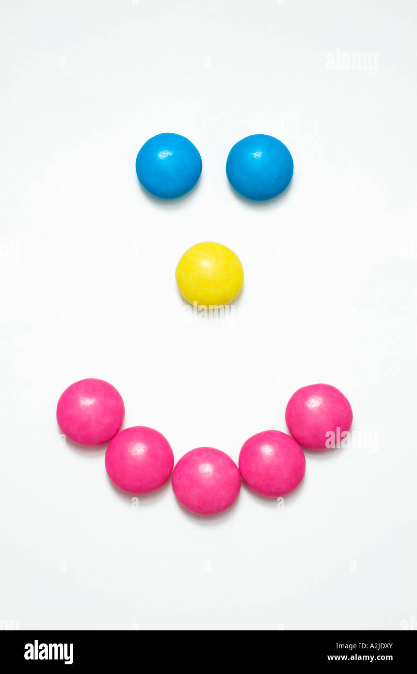 Colourful sweets forming smiley face on white background Stock Photo ...