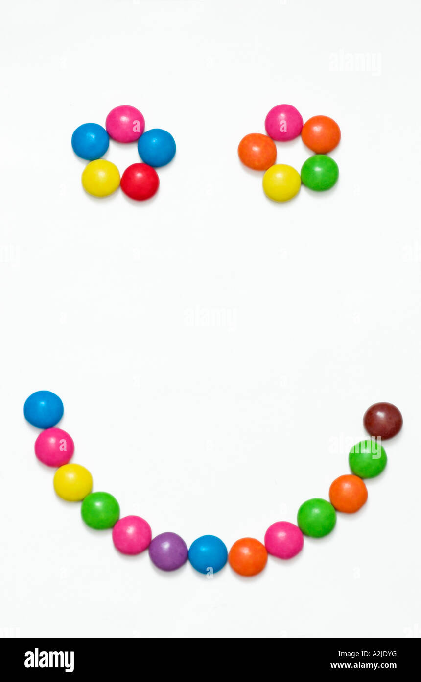 Colourful sweets forming smiley face on white background Stock Photo ...