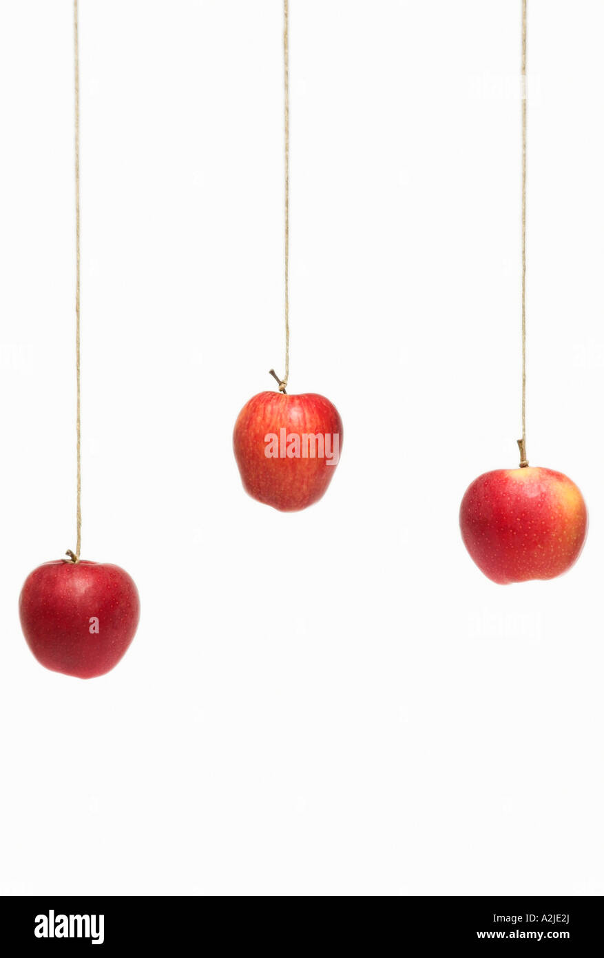 Apples suspended from string, white background Stock Photo - Alamy