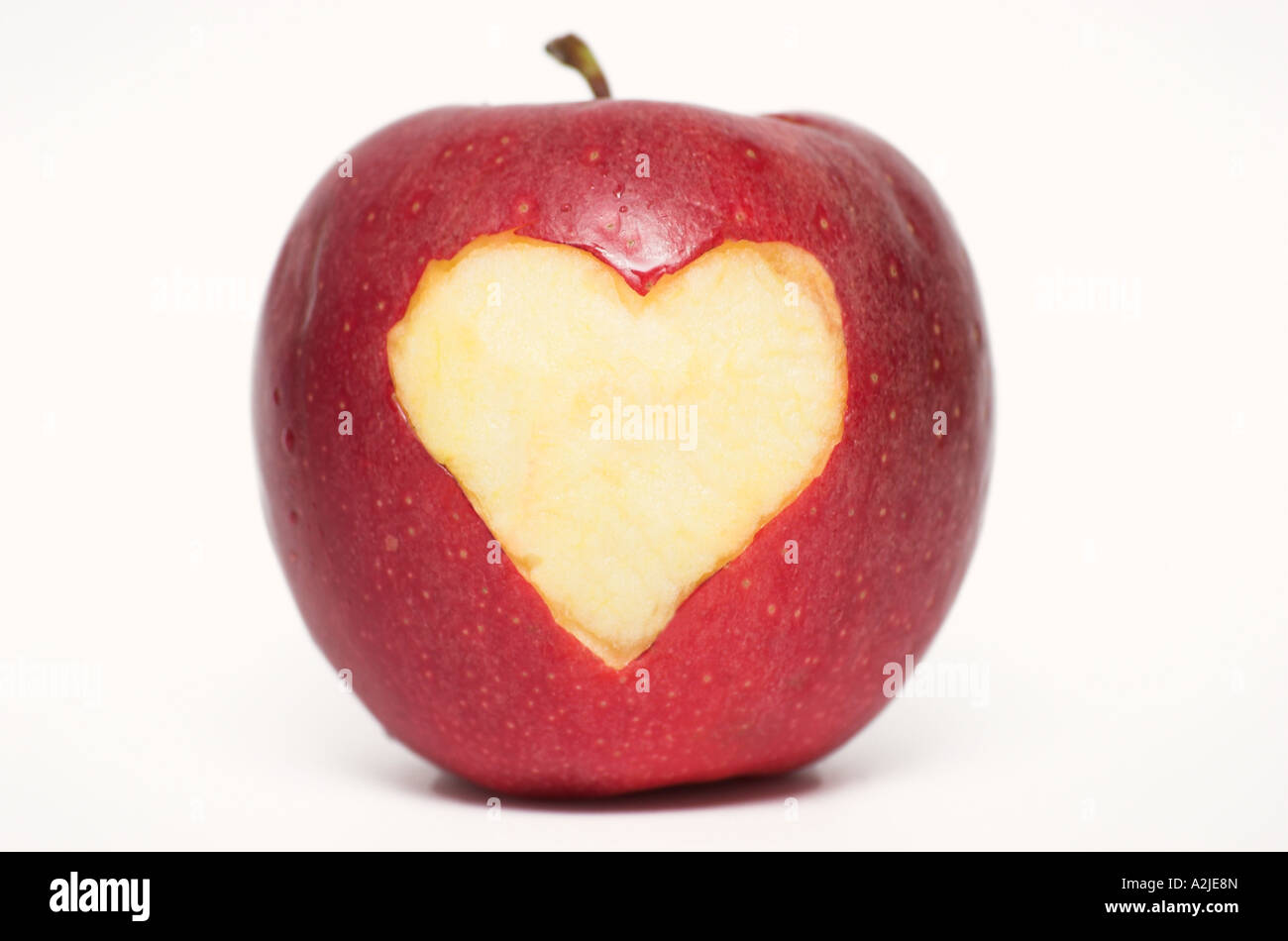 Heart shape symbol on red apple against white background Stock Photo ...