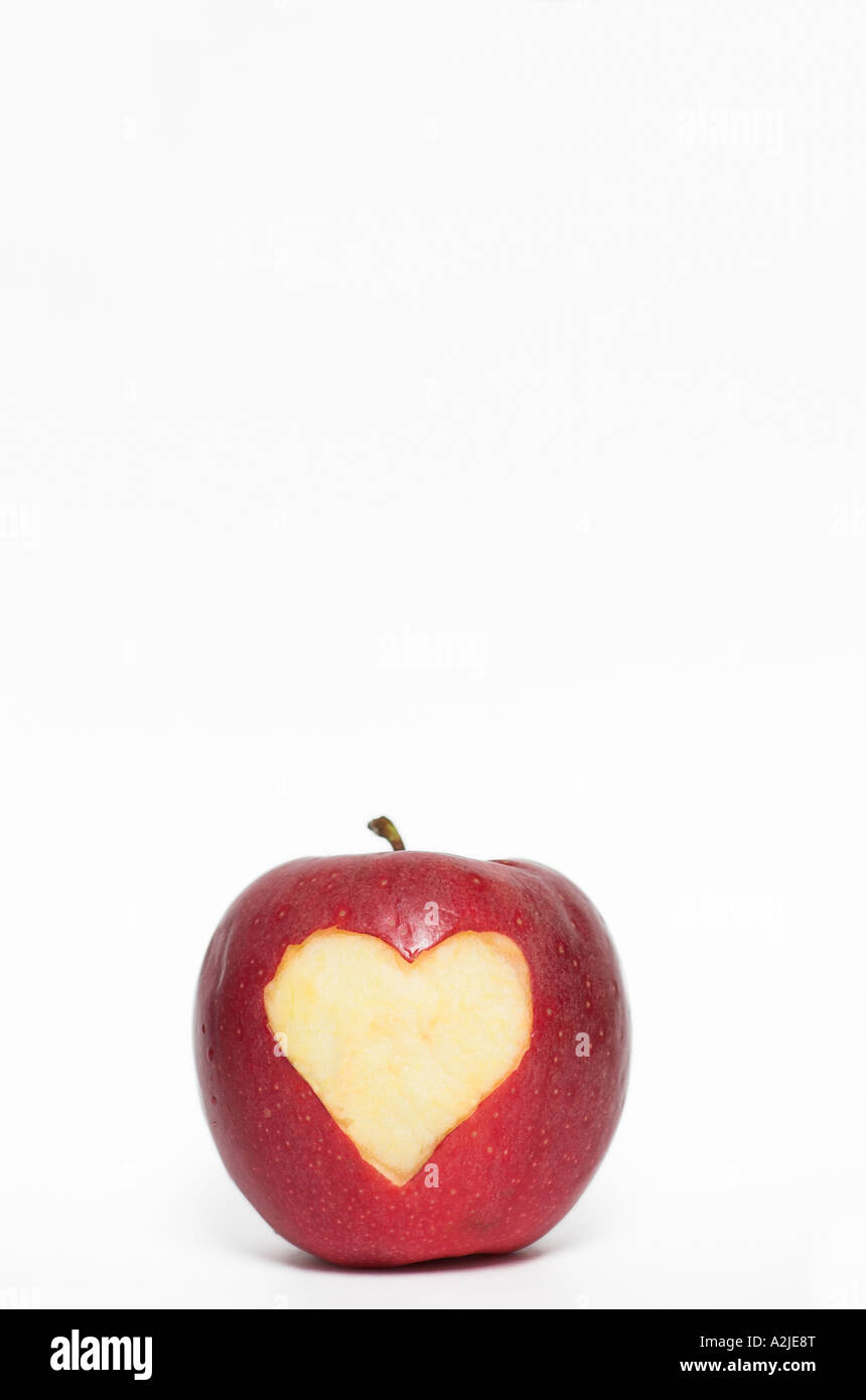 Heart shape symbol carved on red apple against white background Stock ...