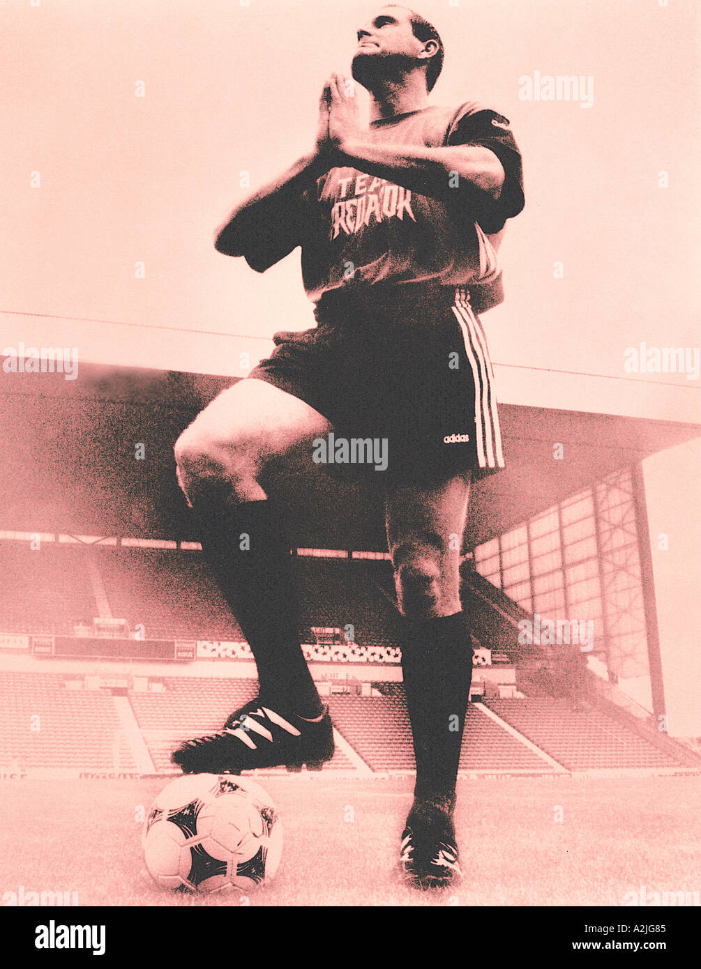 Footballer age 20-25 with his foot on the ball praying Stock Photo - Alamy