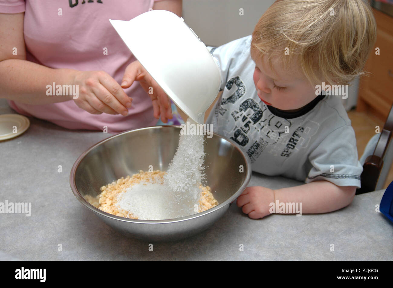 Toddler helping mix ingredients Stock Photo - Alamy