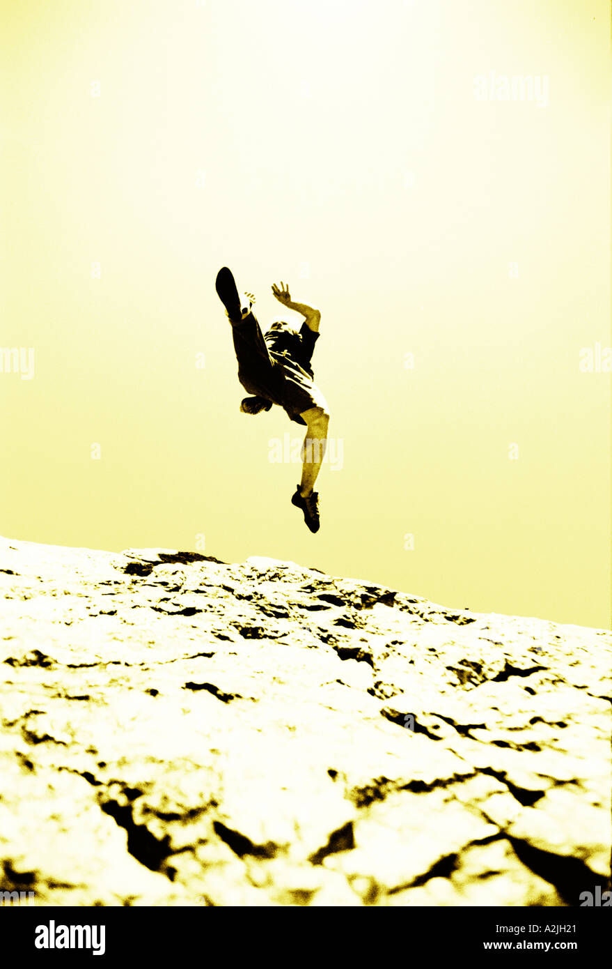 male age 20-25 jumping off a rock. The Image is shot from below Stock ...