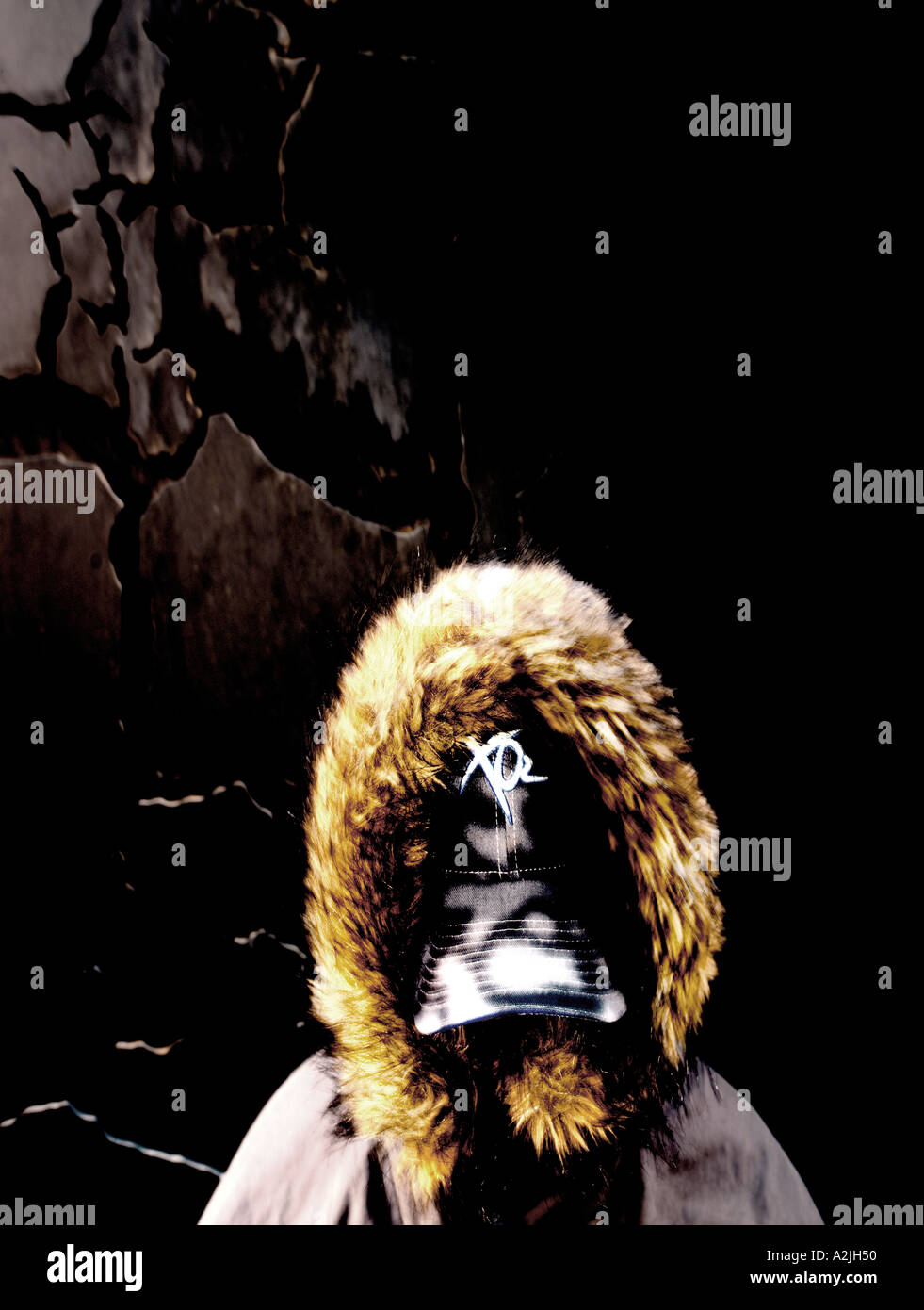 A man age 20-25 wearing a baseball cap and coat with it's hood up so ...