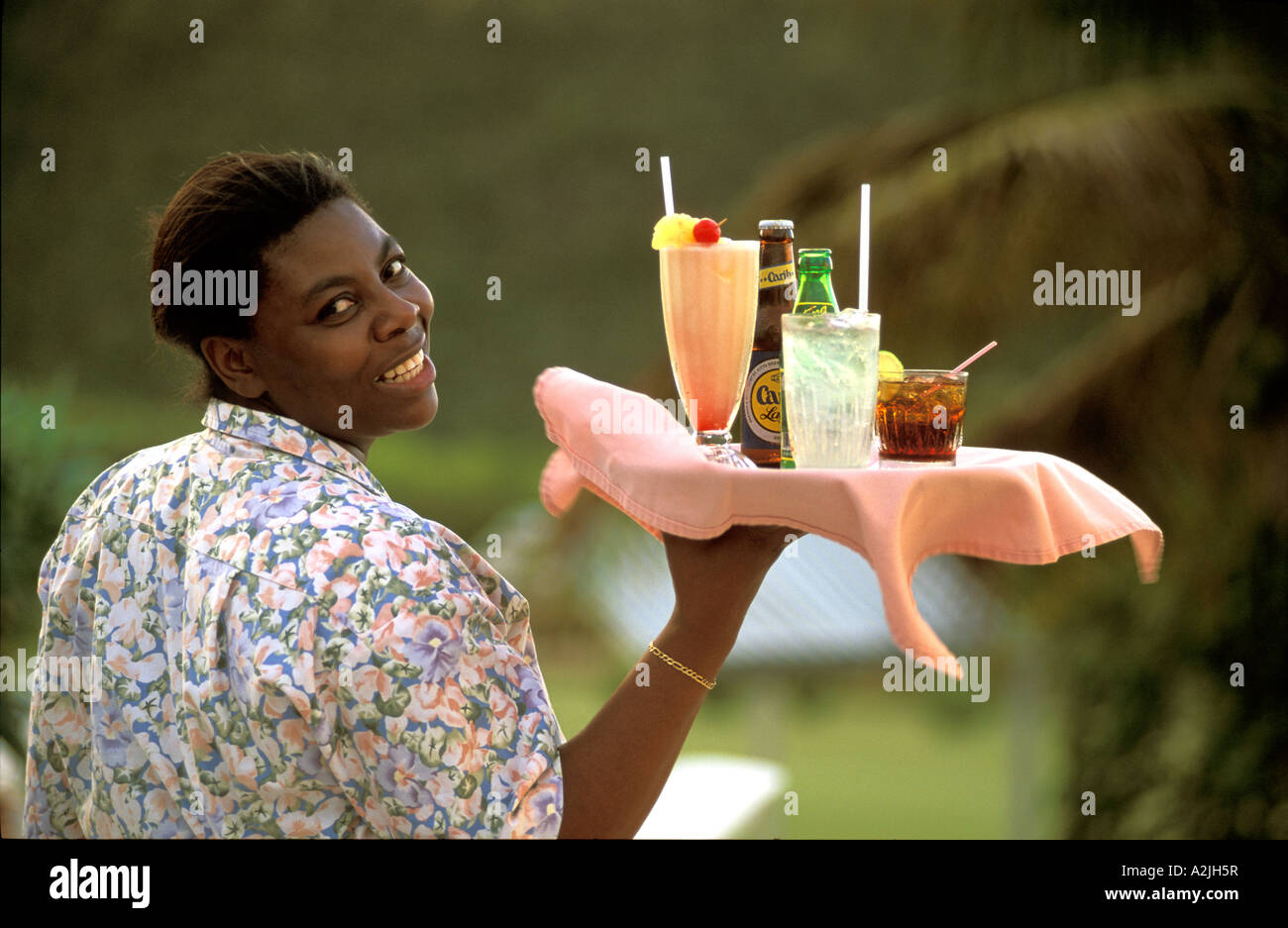 A waitress holds a tray of drinks at the Mount Nevis Hotel resort Stock ...