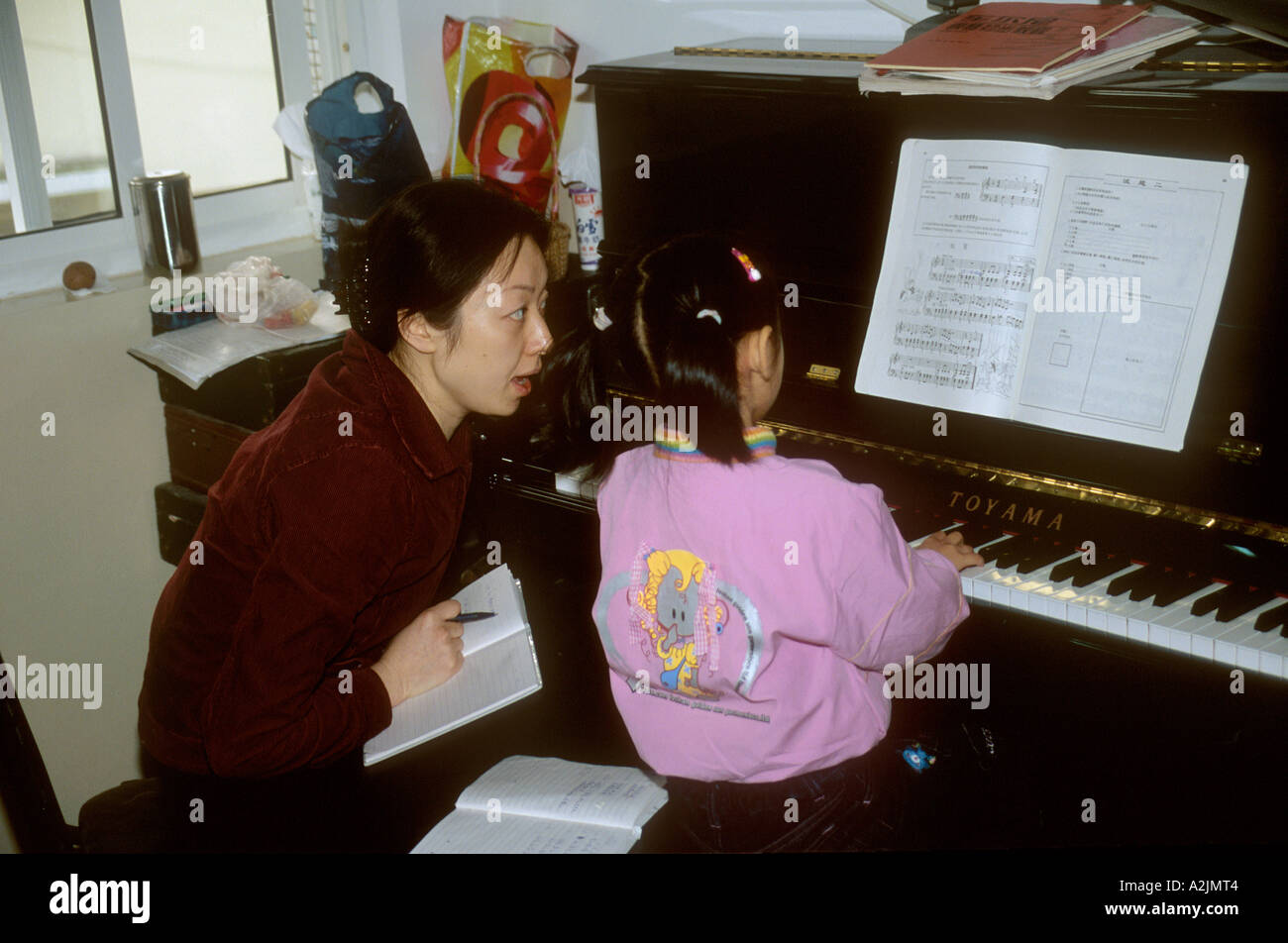 China, Shanghai, Young Chinese child taking piano lessons from ...