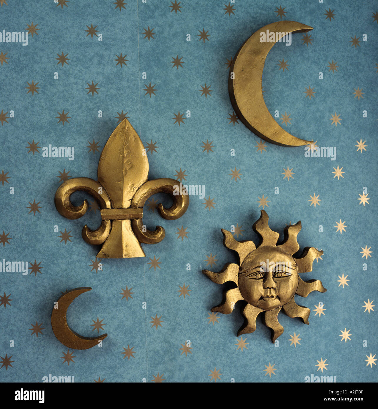 Close-up of gilt celestial ornaments motifs on blue and gold wallpaper ...