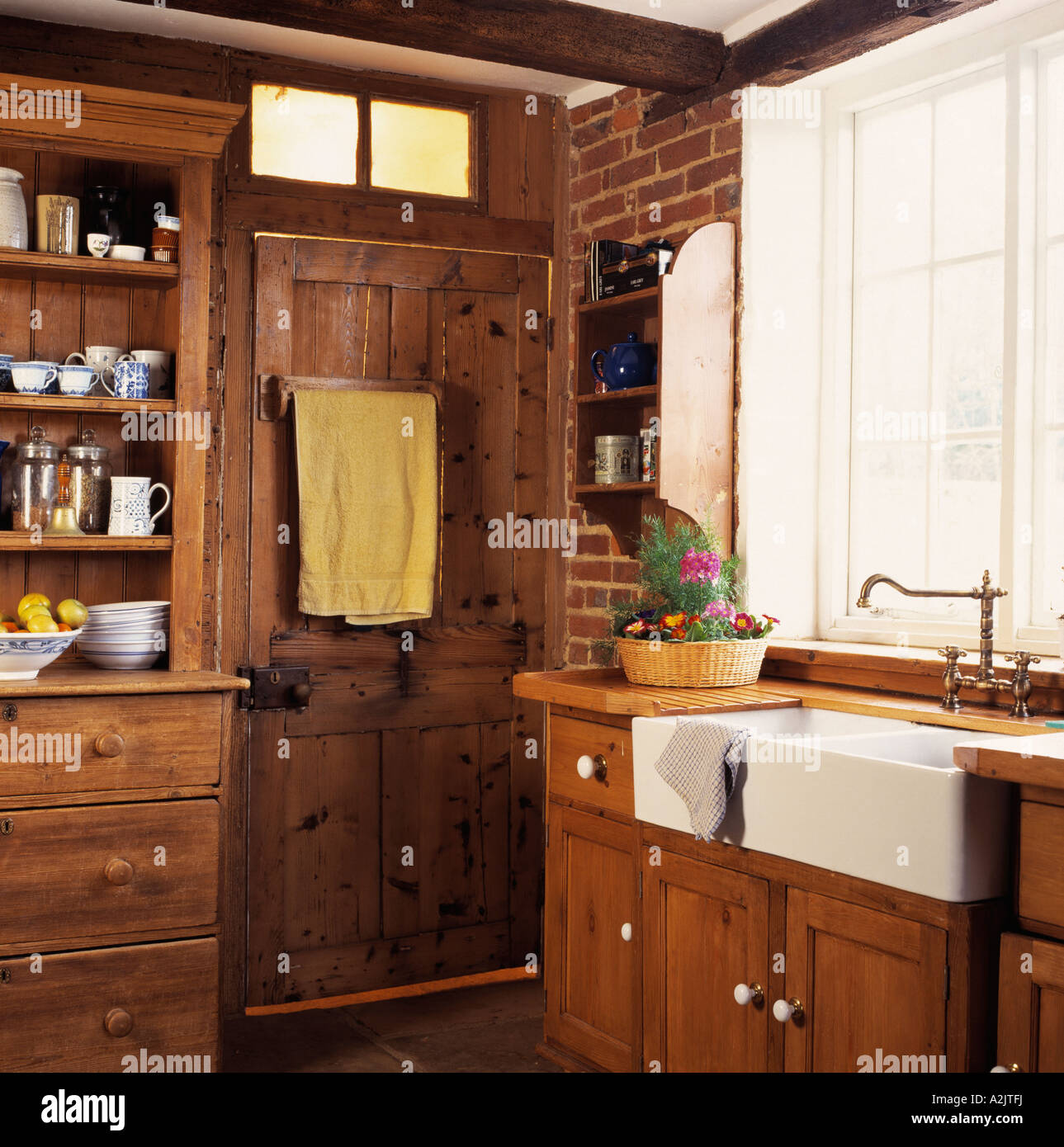 Large ceramic sink in kitchen with wooden door and brick walls Stock ...