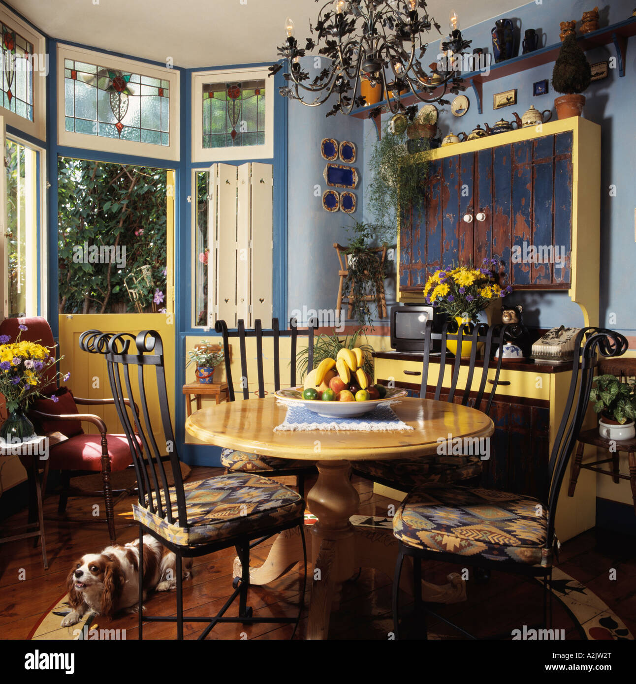 Blue and yellow diningroom with wooden table and metal chairs Stock ...