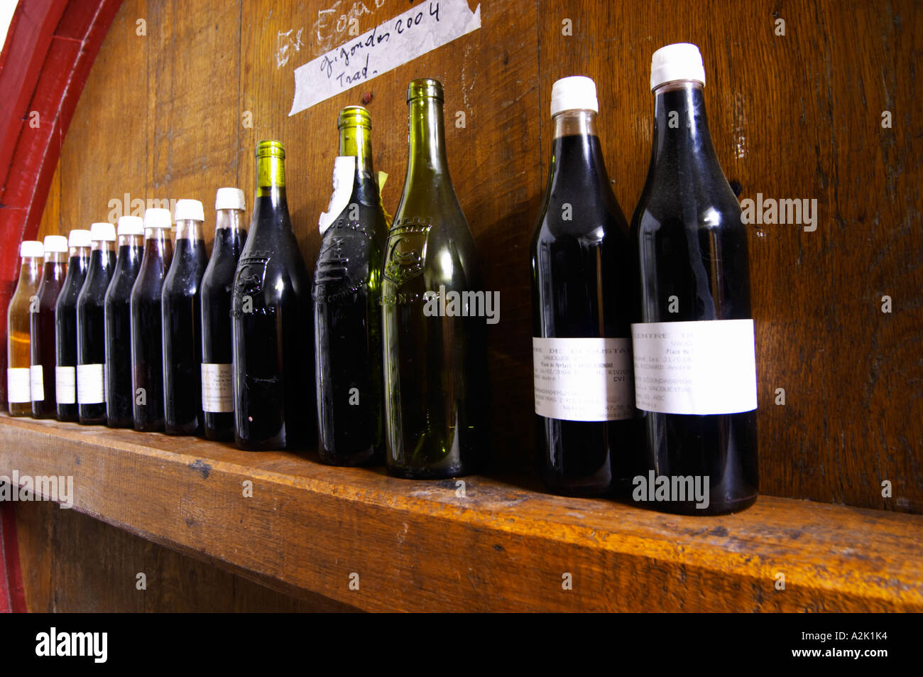 In the winery, big wooden storage vats for aging with sample bottles of ...