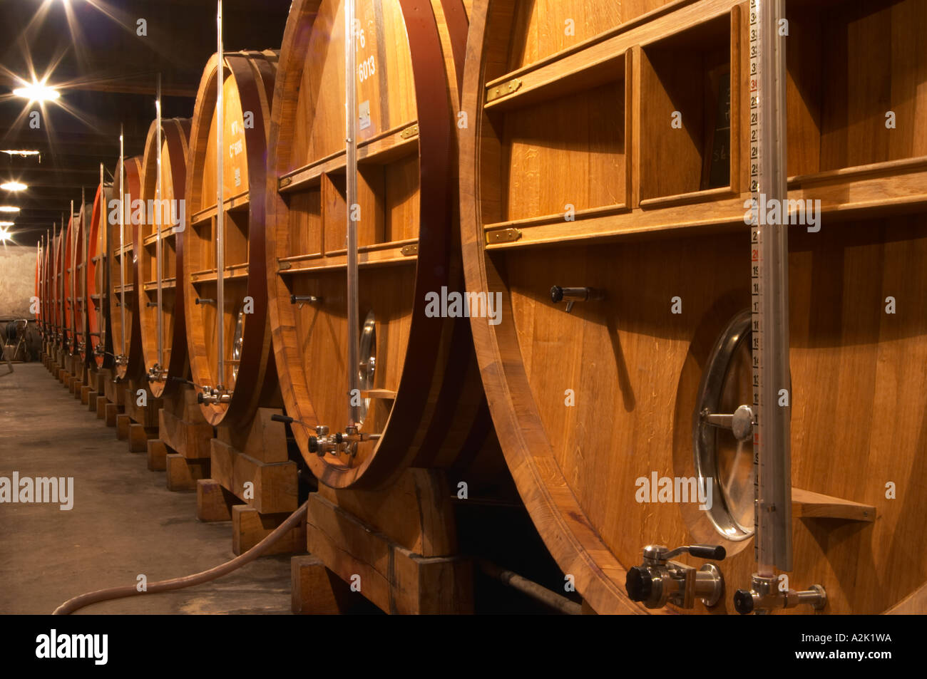 Wooden storage vats with aging wine in the cellar of Guigal in Ampuis ...
