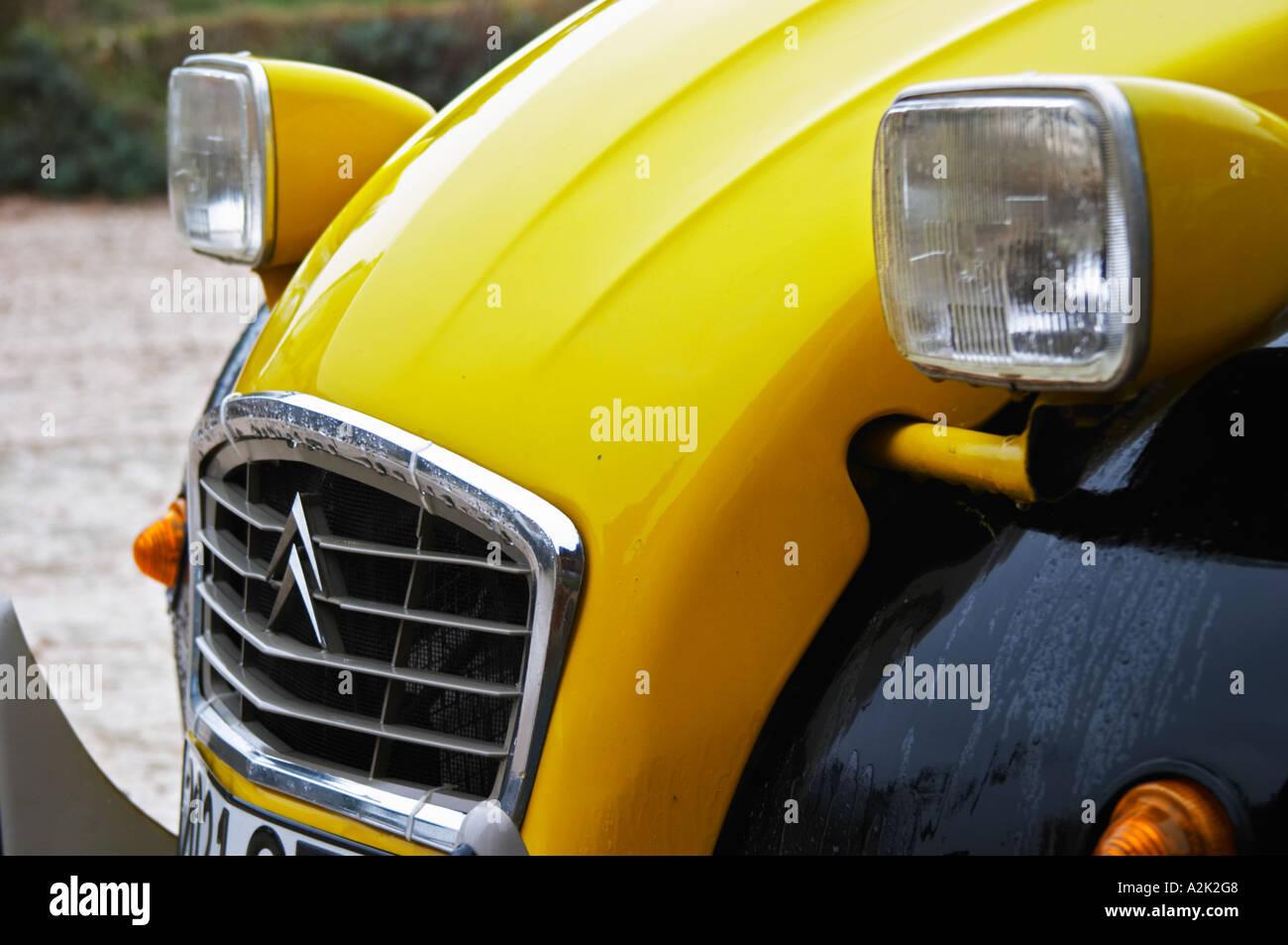 An old black and yellow Citroen 2CV 2 CV, detail of the front headlight ...
