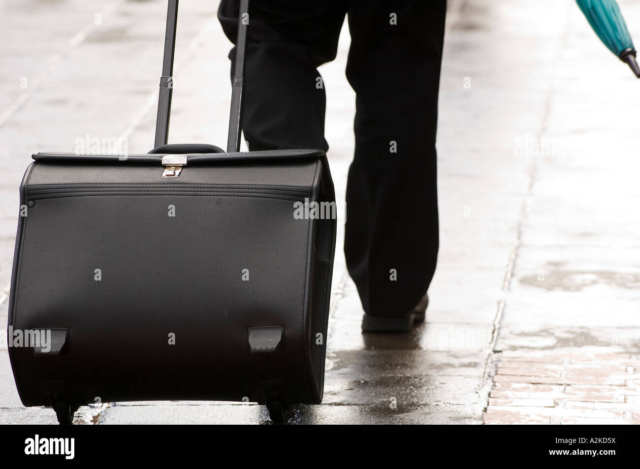 Business man pulling rolling case Stock Photo - Alamy