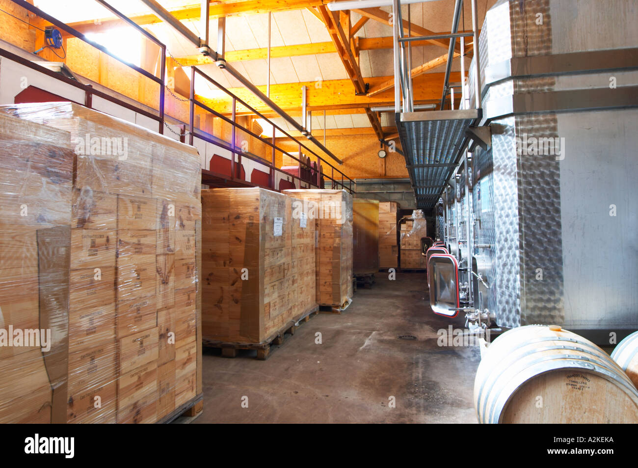 The vat room with stainless steel vats and wooden cases of wine ...