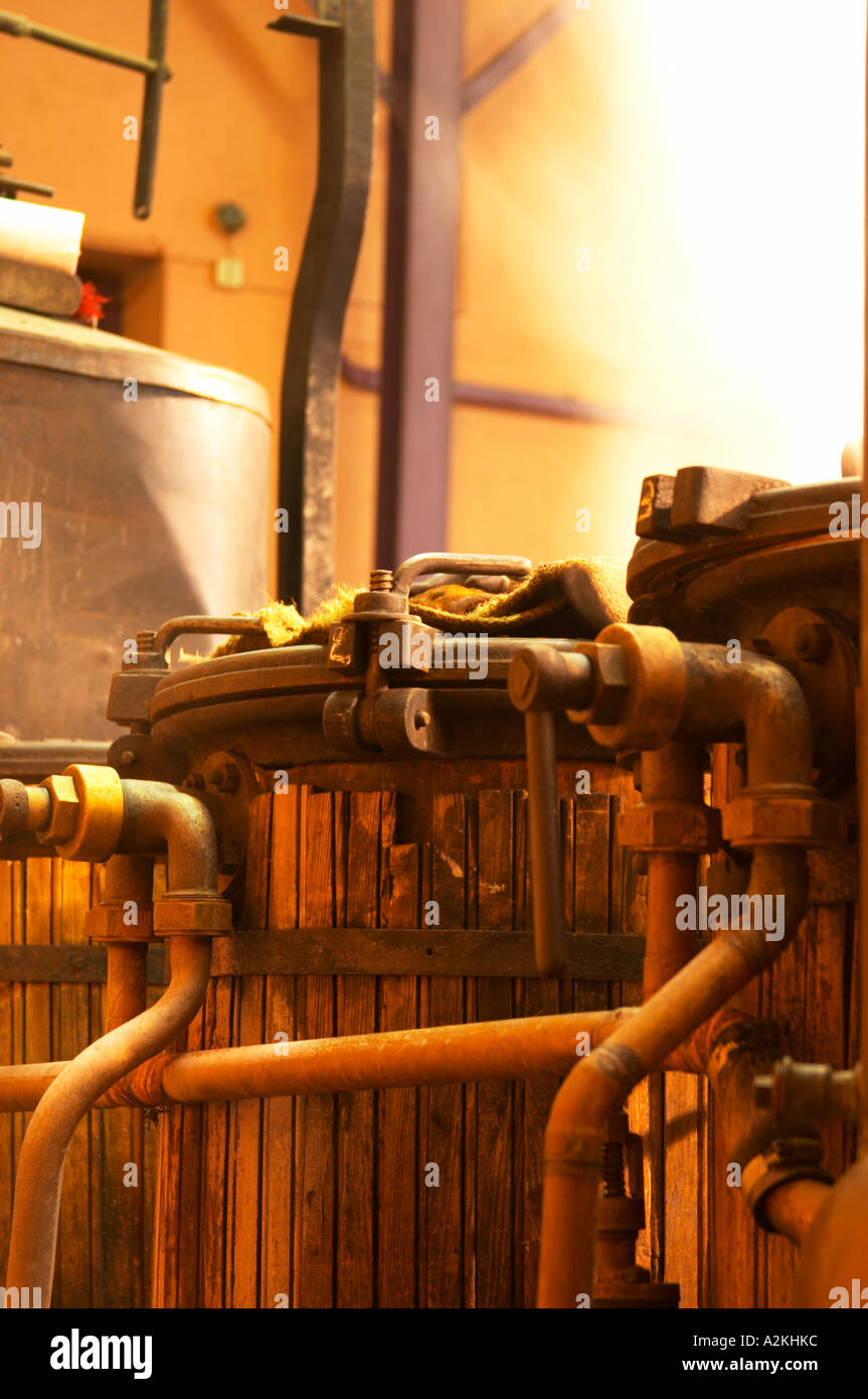 Wooden and copper still with steam coming out of the valves. Detail ...