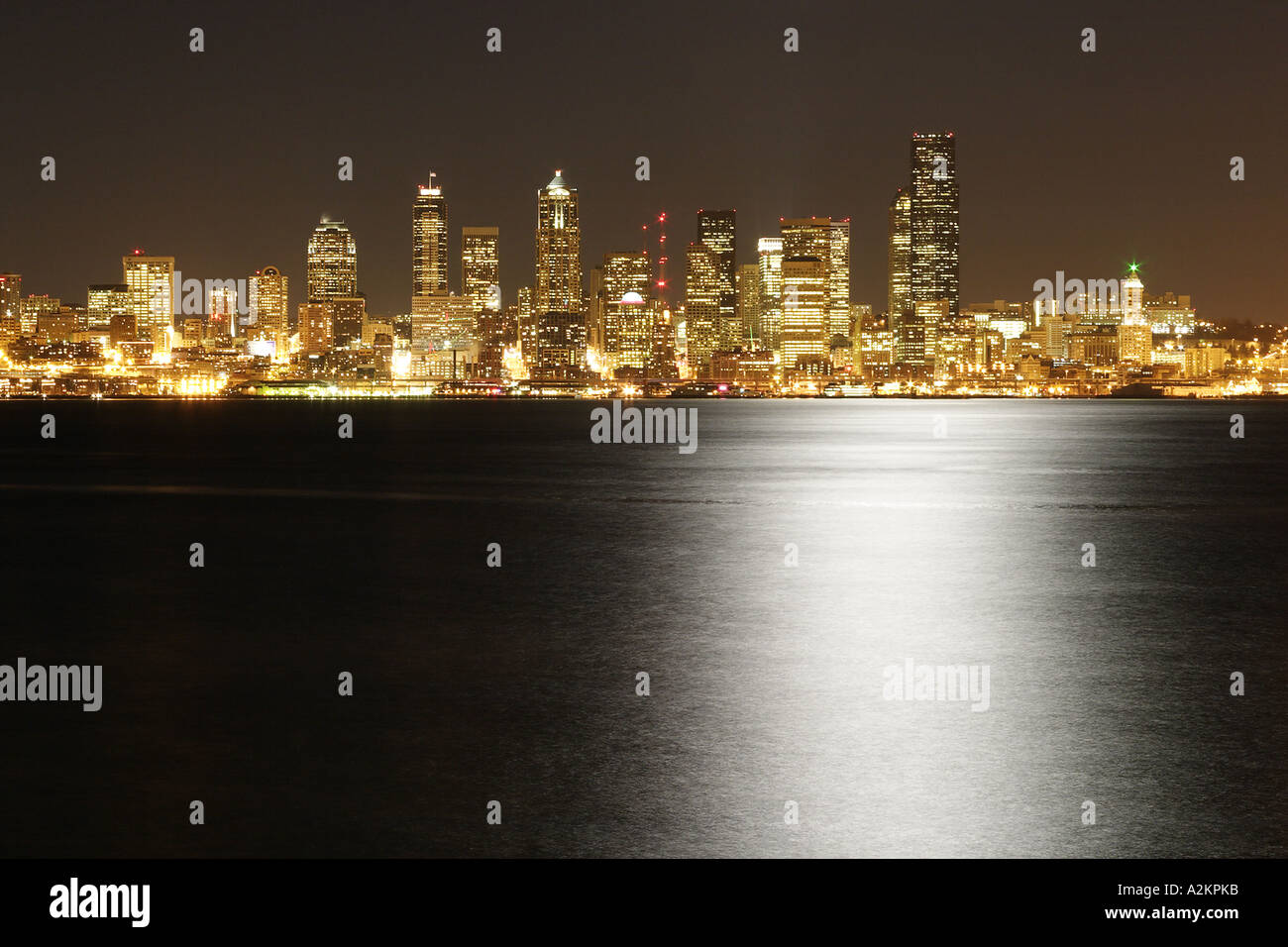 Seattle city skyline at night with light of full moon reflected in ...