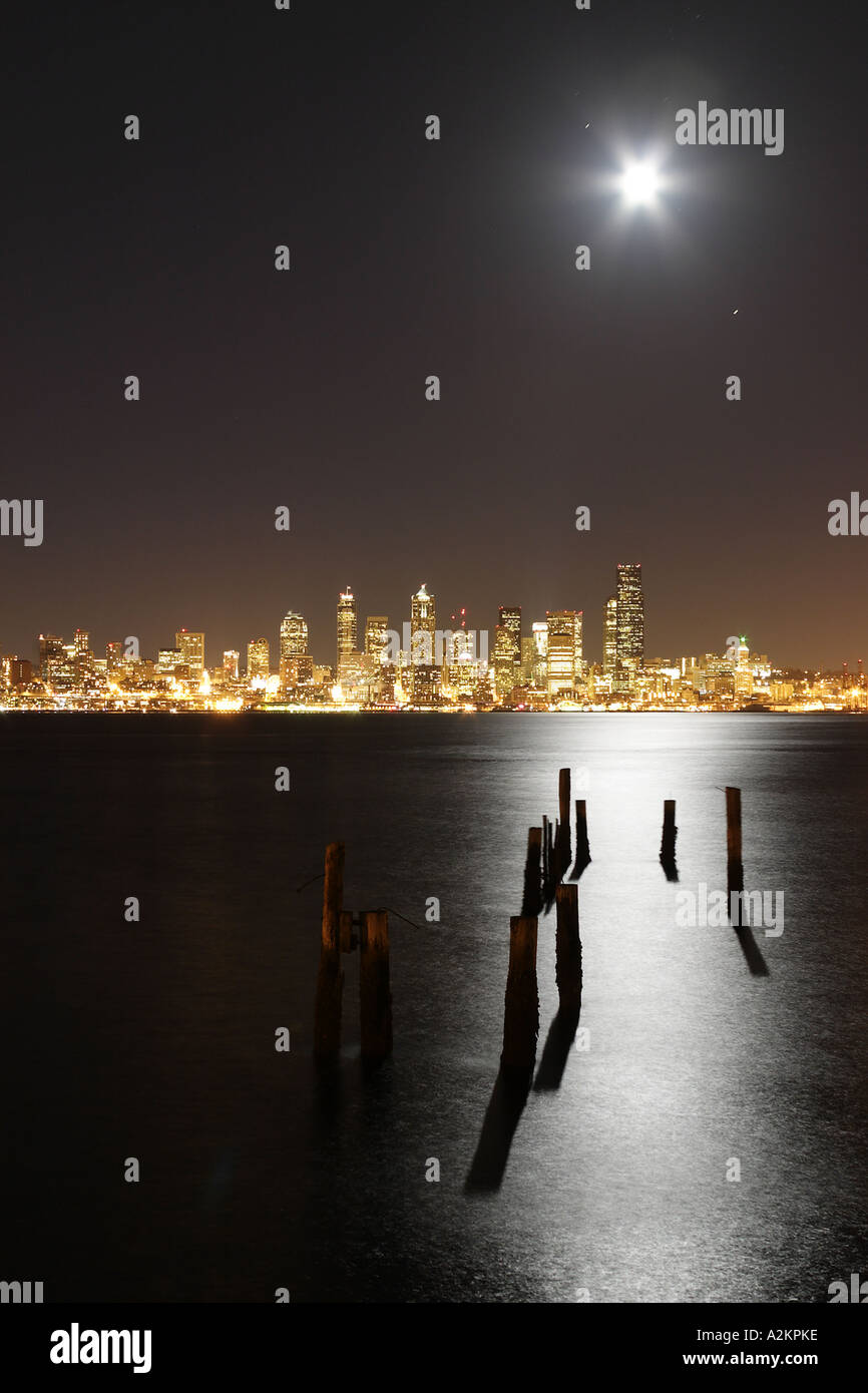 Full moon rising over Seattle city skyline at night pilings silhouetted ...