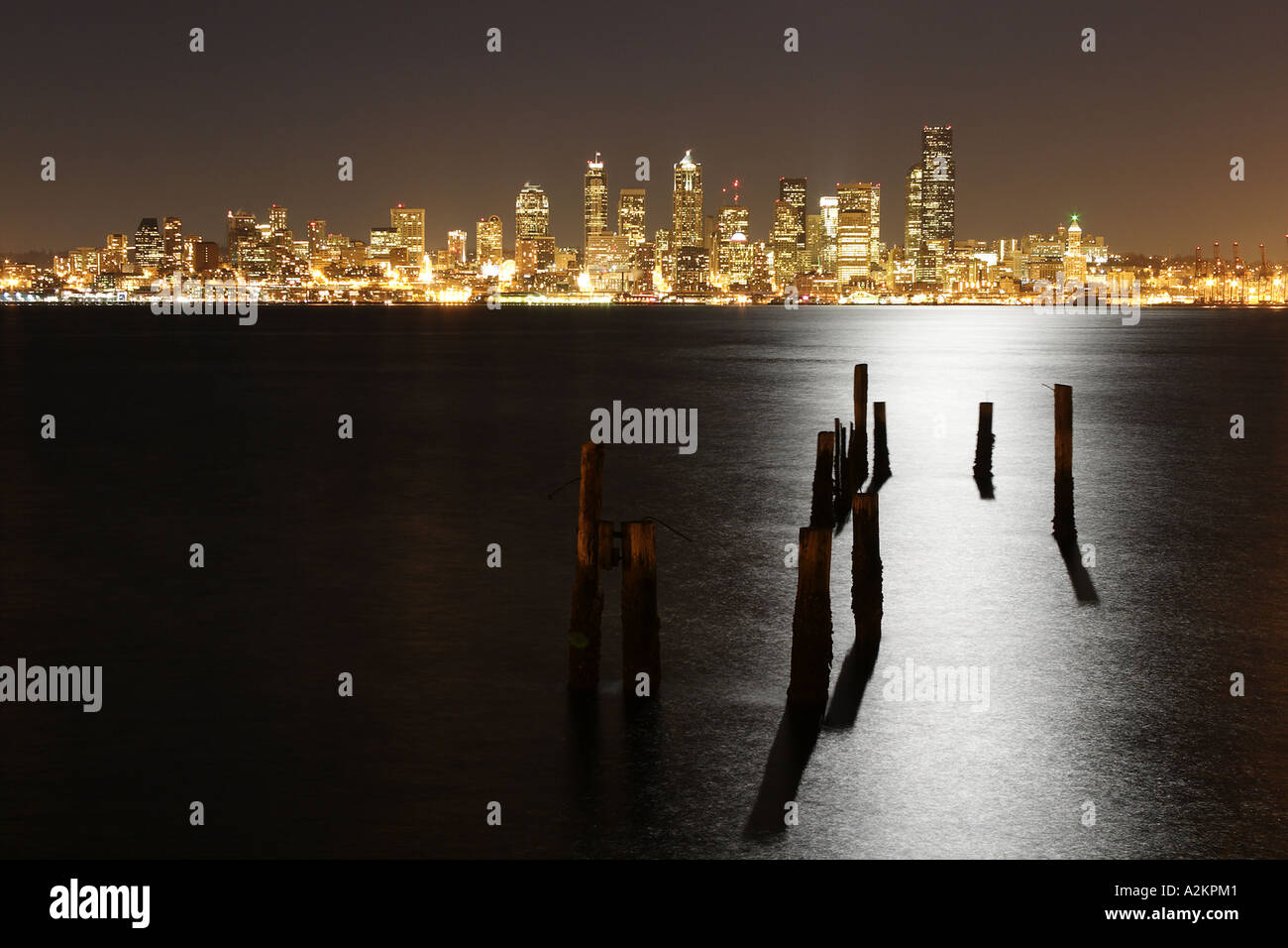 Seattle city skyline at night with pilings and light of full moon ...