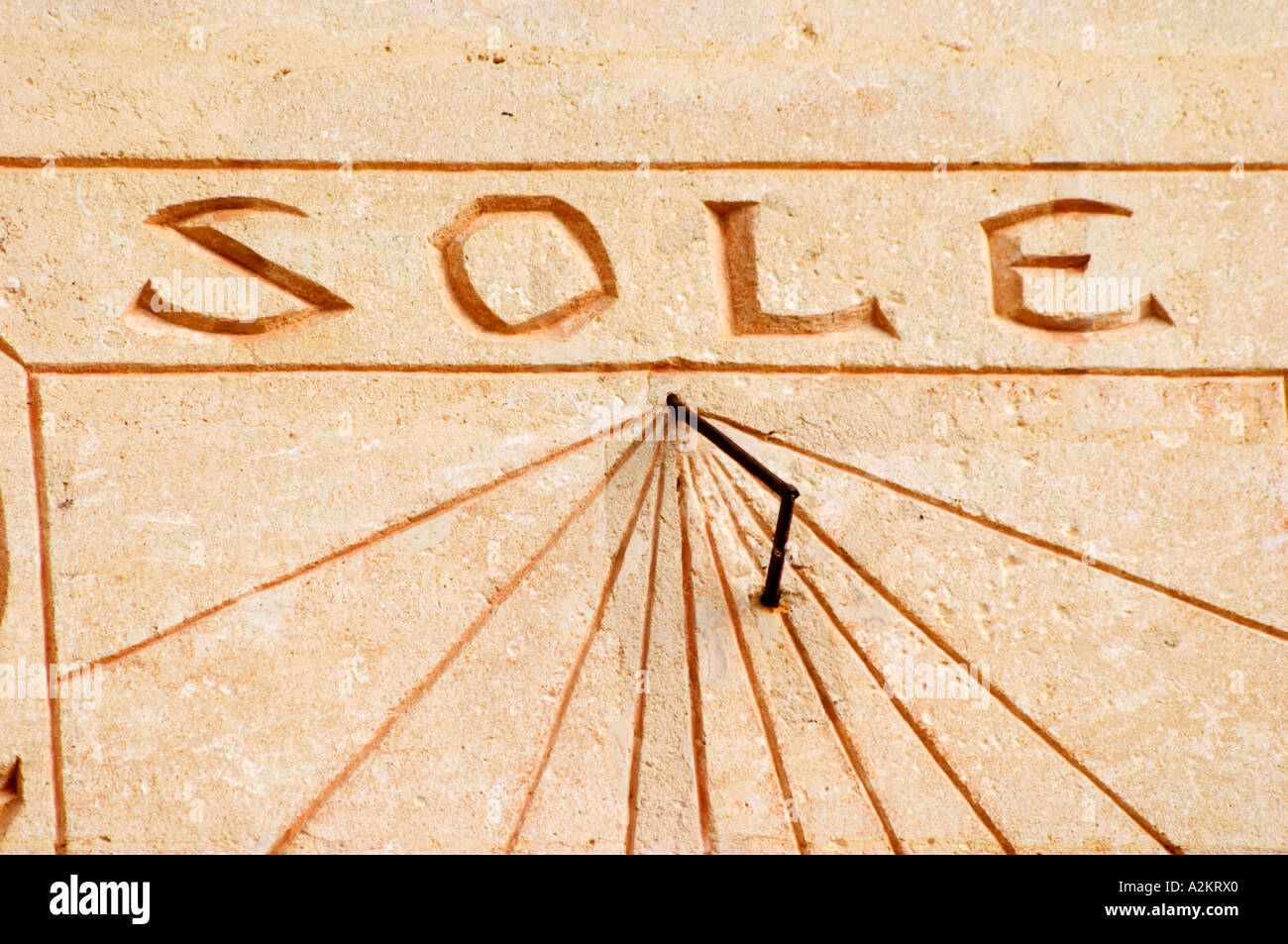 The sun dial on the wall of the building with the carved stone ...