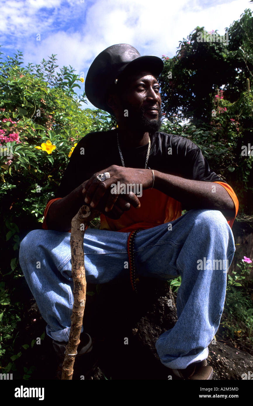 Reggae native man with hat and walking stick in colorful gardens near ...